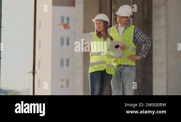 Construction worker man and architect woman in a helmet, discuss the ...