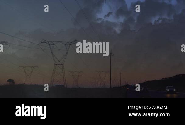 Digital composite of transmission towers in a field during sunset shows ...