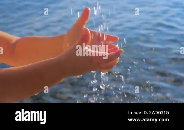 Infant hands. Little baby washing hands in clean water on seascape ...