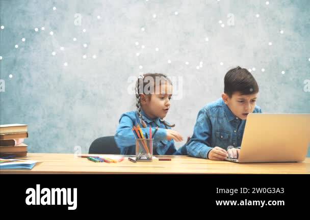 Lovely girl is drawing, her brother is searching in the internet. She ...