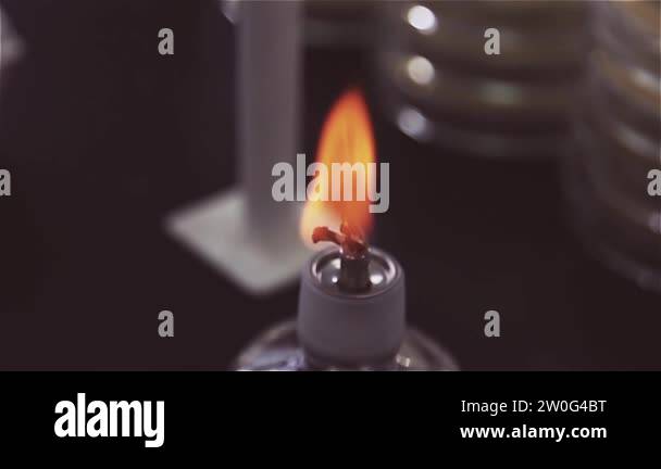 In the laboratory on the table a glass alcohol burner burns ...