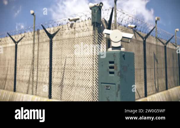 CCTV camera monitoring heavily guarded building, penitentiary, military ...