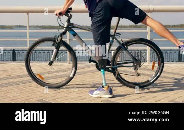 Paralympian with a prosthetic leg is driving away on a bike Stock Video ...