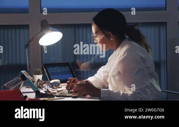 Female electronics engineer working with multimeter tester and other ...