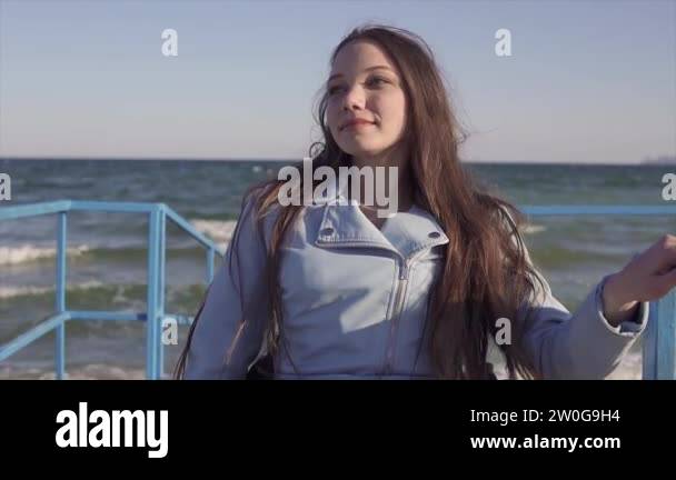 Young disabled woman in wheelchair resting near the sea on the ramp for ...