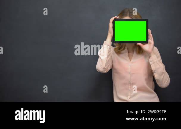 Girl hiding face behind green screen, concept of anonymity on internet ...