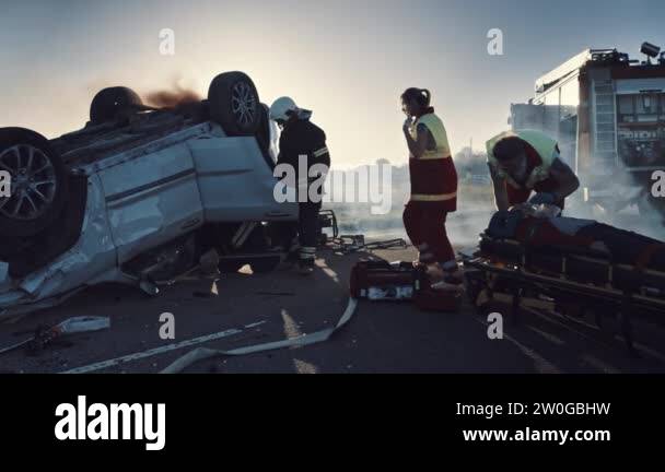 On the Car Crash Traffic Accident Scene: Paramedics Giving First Aid ...