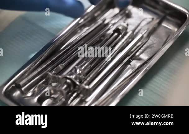 dental surgeon is choosing and taking steel sterile tool from metal box ...