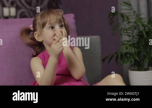 Little child sitting while watching TV. Scared kid girl watch horror ...