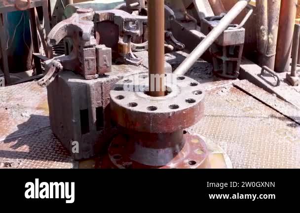 The lifting mechanism of the rig slowly lifts the metal pipe out of the ...
