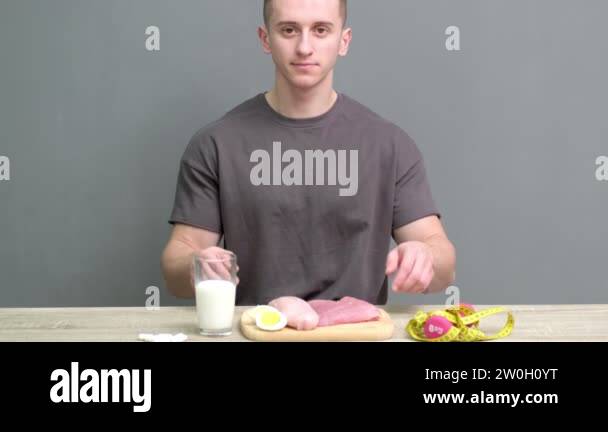 Healthy eating concept. Man of athletic build eats healthy food high in ...