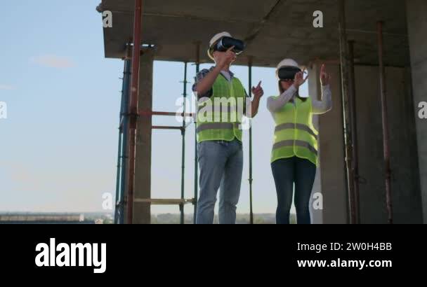Two contemporary crew workers using VR to visualize projects standing ...