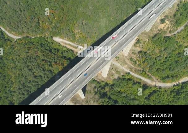 Drone top view of bridge motorway with speeding trucks and cars during ... Drone top view of bridge motorway with speeding trucks and cars during ...