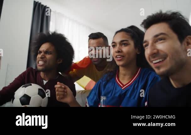 Handheld video of football fans watching TV and actively cheering. Shot ...