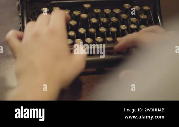 Female hands slowly typing on the old typewriter with russian letters ...