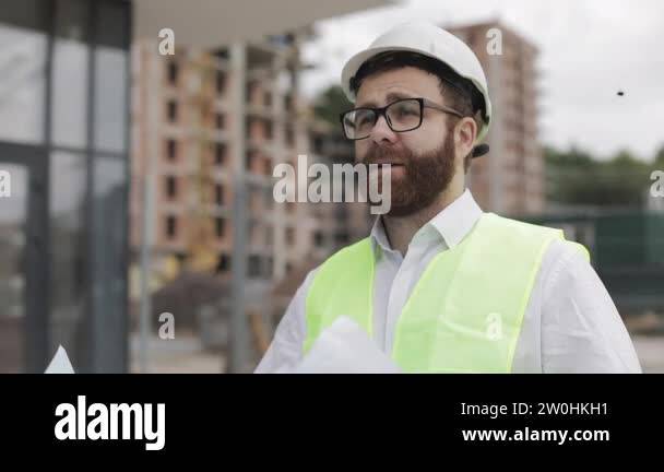 Architect man walking on the construction site and analyzing scheme ...