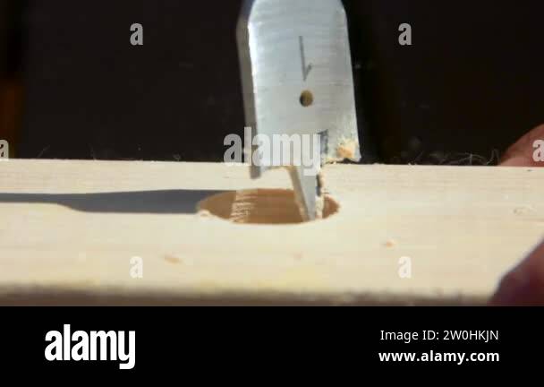 Drilling a hole in the board using a drill and a flat drill with a ...