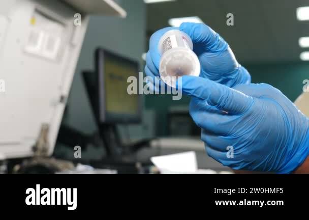 Biological medical lab reseach. Hands in blue gloves, holding a medical ...
