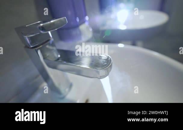 Hot tap water. Warm water flows from the tap in the bathroom ...