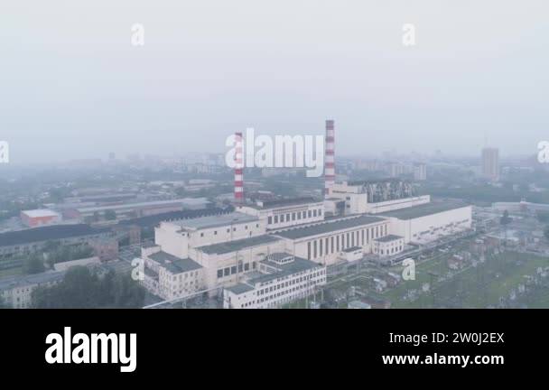 industrial buildings with pipes and the city shrouded in smoke. air ...