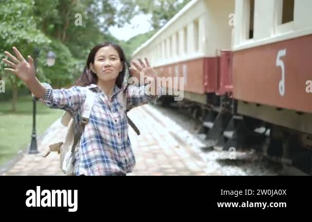 4K. Asian tourist woman waving hands to say goodbye in departe leaving ...