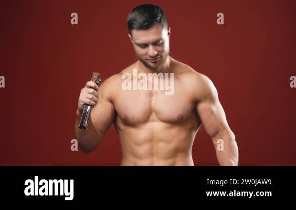 Sportsman choosing vitamins. Muscular athlete holding sweet chocolate ...