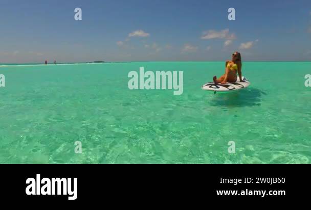 video of the athletic girl sunbathing on the surfboard and swinging on ...