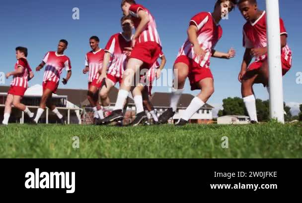 Low angle side view of a teenage multi-ethnic male team of rugby ...