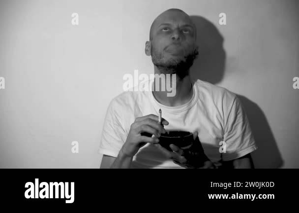 Young nervous smoker man smoking cigarette in cloud of smoke after ...