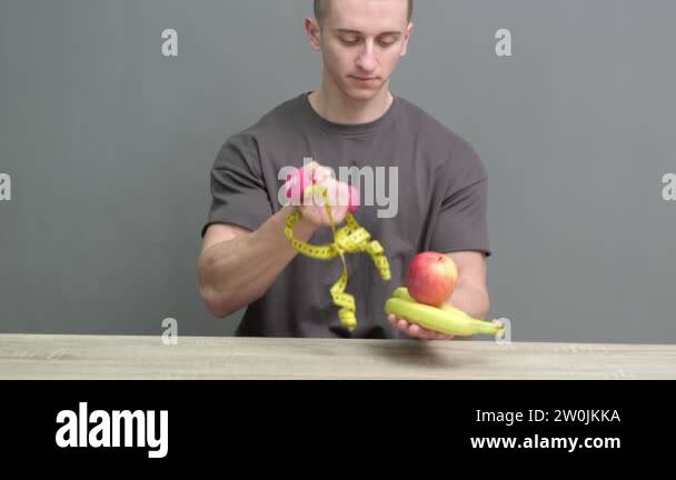 Healthy eating concept. Man of athletic build eats healthy food high in ...