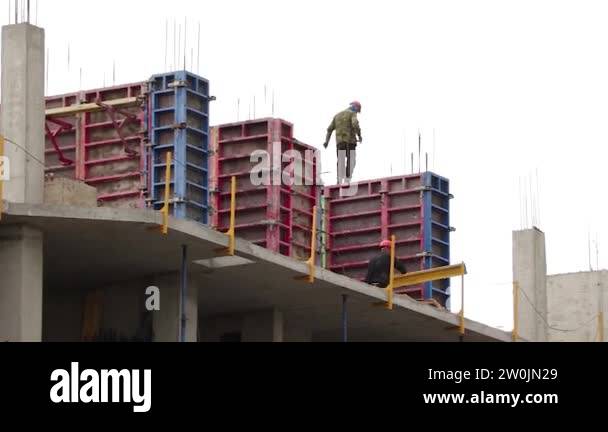 Builders are building a multi-storey house. Workers install walls in a ...