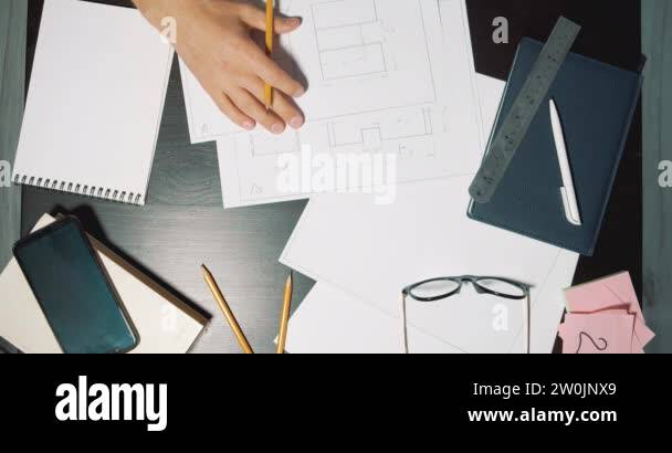 Close up of male hands holding paper sheets with drawings checking them ...