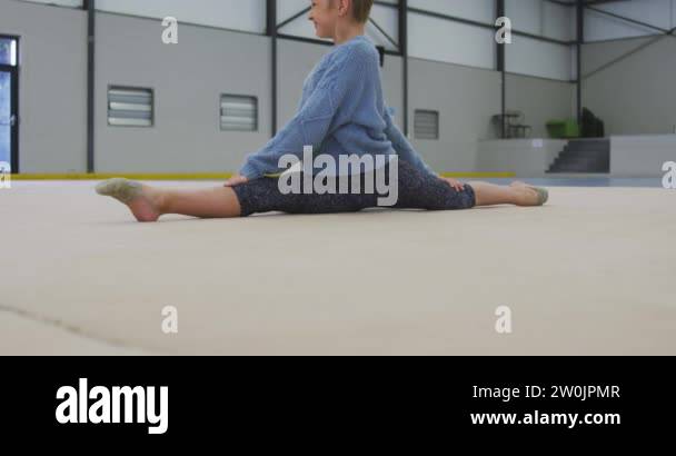 Low angle side view of a teenage Caucasian female gymnast practicing at ...