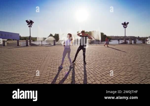 Man and woman dancing outdoors. Young couple moving synchronously in ...