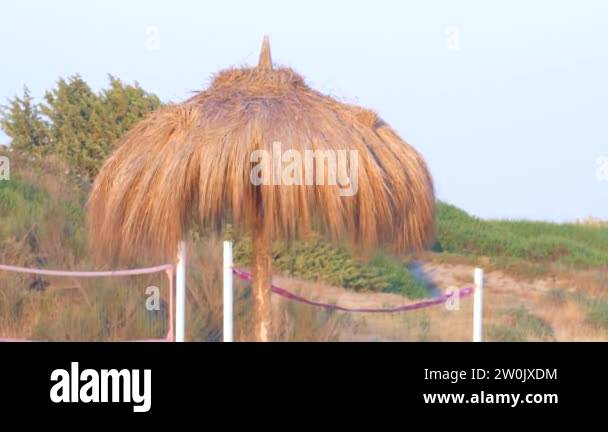 Handmade straw canopy on the beach. Sun umbrella on sandy beach ...