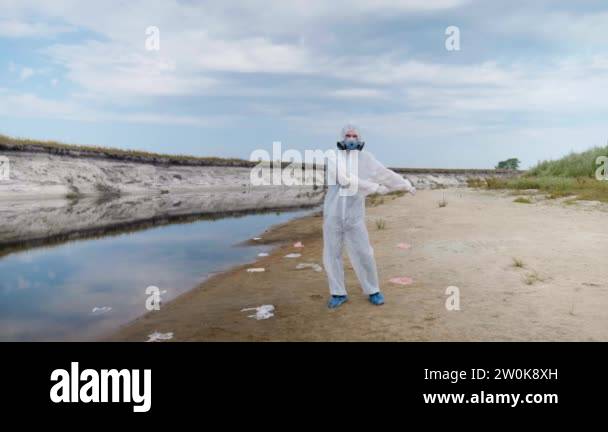 A man in a protective suit and respirator performs a popular dance by ...