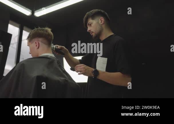Male haircut with electric razor. Barber makes haircut for client at ...