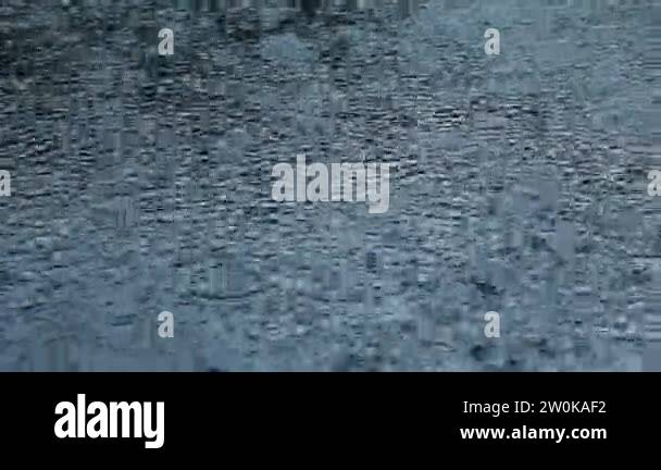 Rain drops fall on water surface of pond, lake or river forming a ...