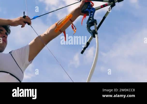 Loaded compound bow with the pulled string in male hands. Shooting with ...