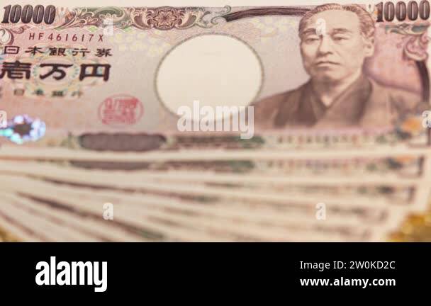 Close-up rack focus video on 100,000 yen in cash on a golden paper ...