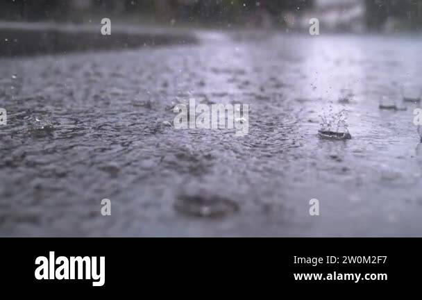 SLOW MOTION CLOSE UP: Autumn rain water drops falling into big puddle ...