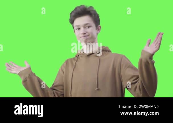 Middle shot of surprised Caucasian boy raising hands and looking around ...