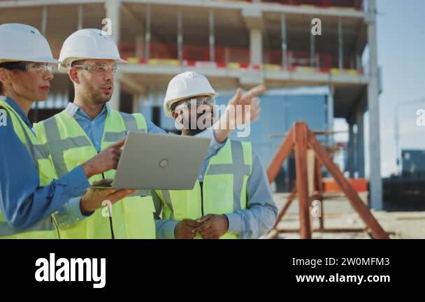 Diverse Team of Specialists Use Laptop Computer on Construction Site ...