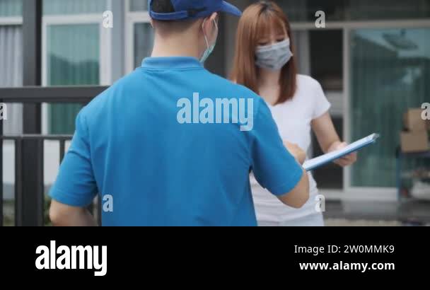 Door to door delivery express sending send a package wearing mask to customer receiver sign ...
