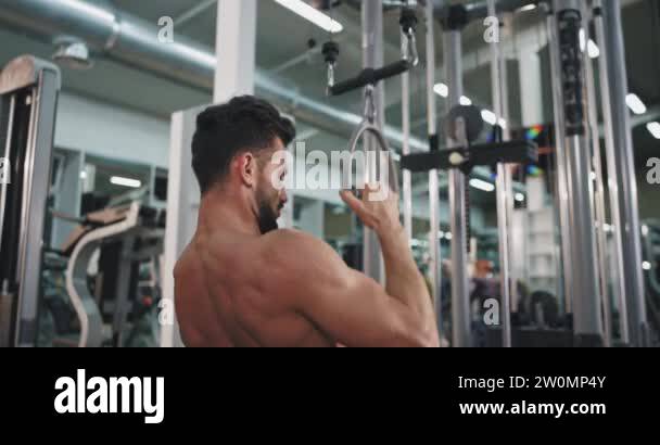 Portrait of a concentrated man with fit body working at gym lifting ...