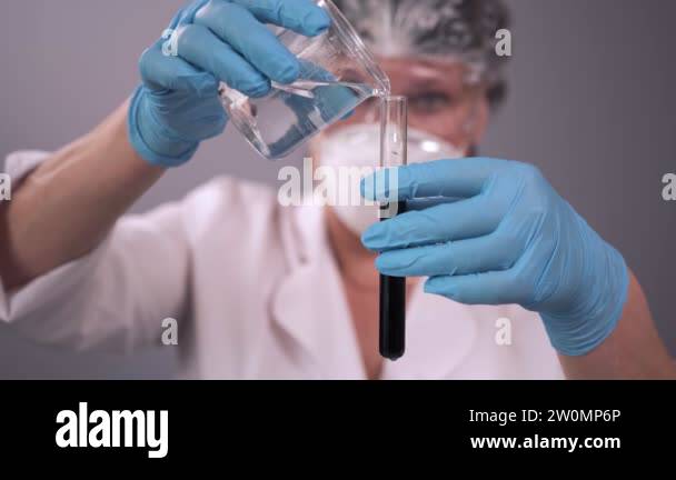 Close-up, A female scientist in protective clothing doing tests, mixing ...
