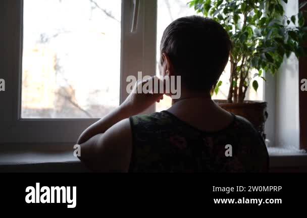 Back view of grandmother looking out window. Concept. Elderly woman ...
