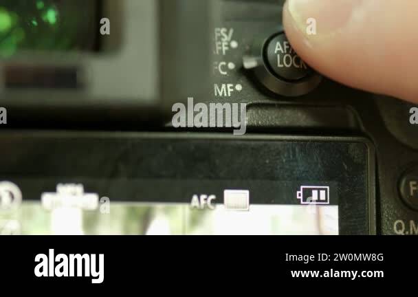 Close clip of photographer changing autofocus setting via a dial on the ...