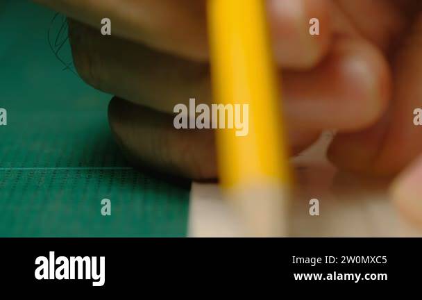 Close-up of male architect hands drawing a line on white paperboard ...
