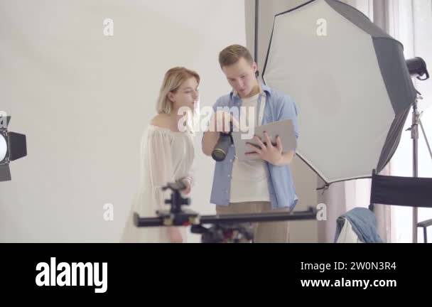 Backstage of the photo shoot. Young successful photographer shows ...